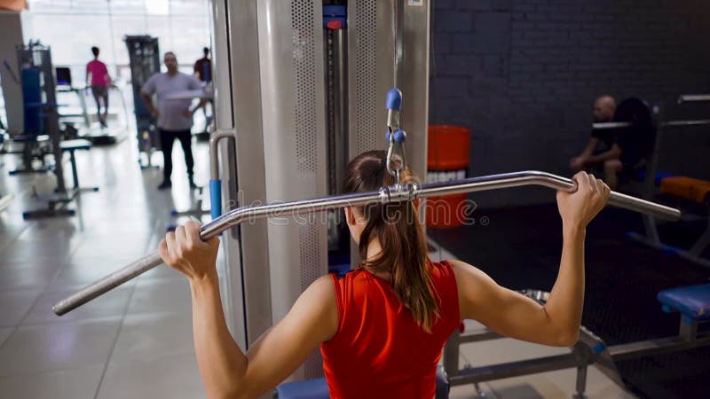 The Athlete Does a Strength Exercise on the Muscles of Her Back and ...