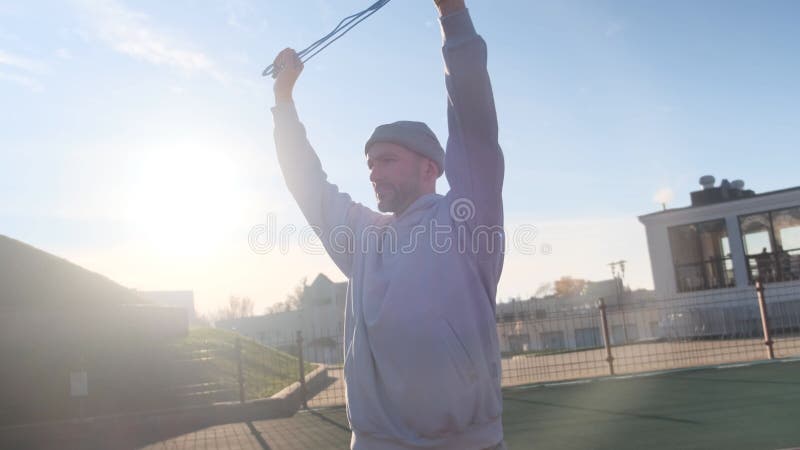 An Athlete Does a Warm-up with a Skipping Rope on the Stadium Track ...