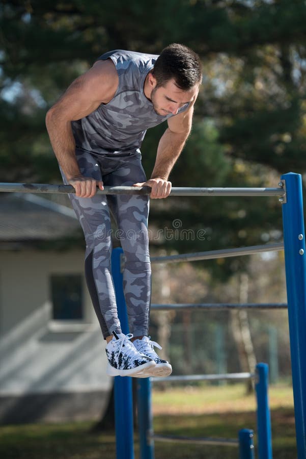 Athlete Doing Exercise with Dips Bar in Park Stock Photo - Image of ...