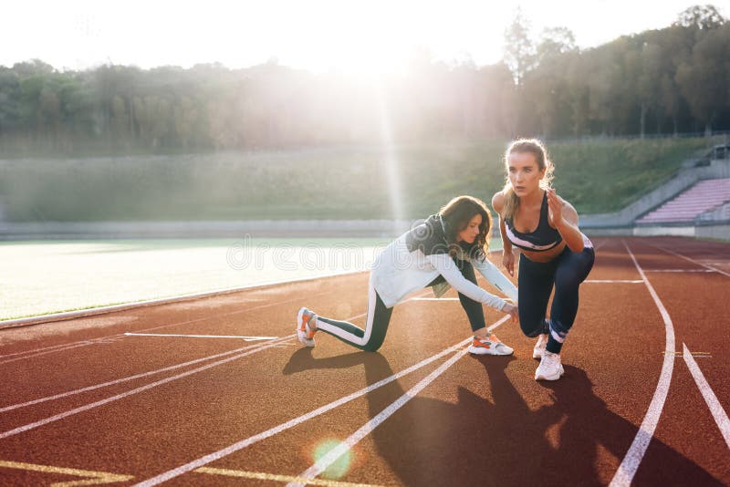 Athlete Exercises with Personal Trainer Standing on Start on Stadium ...