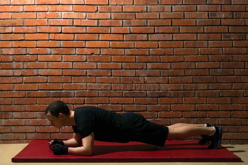 Athlete in the Hall Doing an Exercise on a Red Mat for Training a Press ...