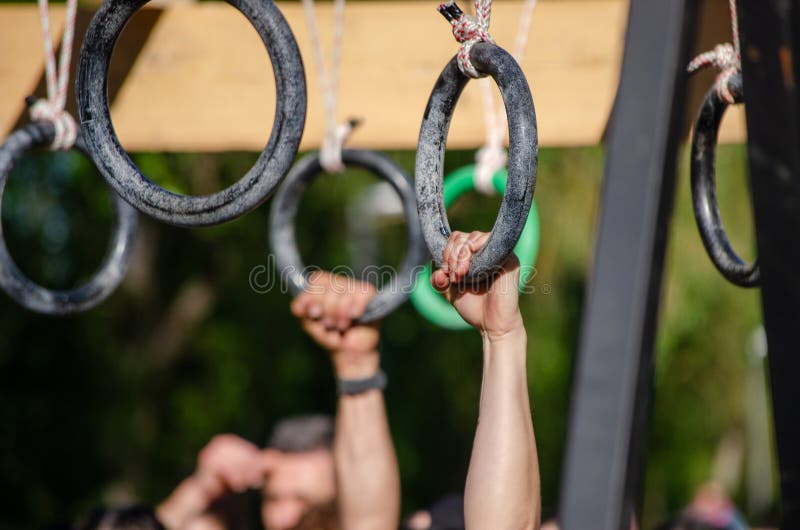 Athlete Hands Grasp a Rings at a Hanging Obstacle in an OCR Obstacle ...