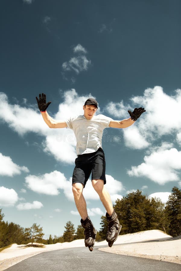 Athlete Inline Skating Practices Jumping Tricks on an Asphalt Track ...