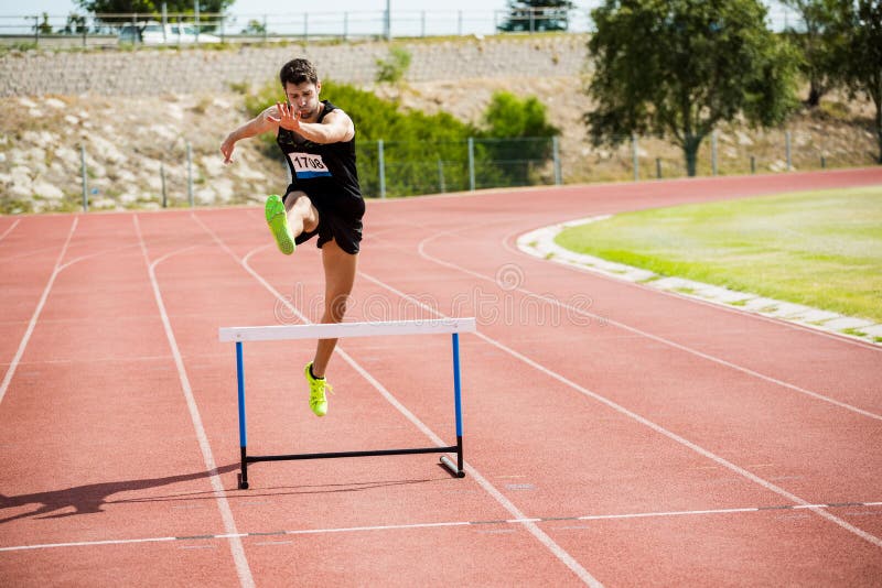 Athlete Jumping Above the Hurdle Stock Photo - Image of power, sunny ...
