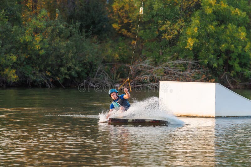 An Athlete Jumps Over the Water. Wakeboard Park at Sunset Stock Image ...