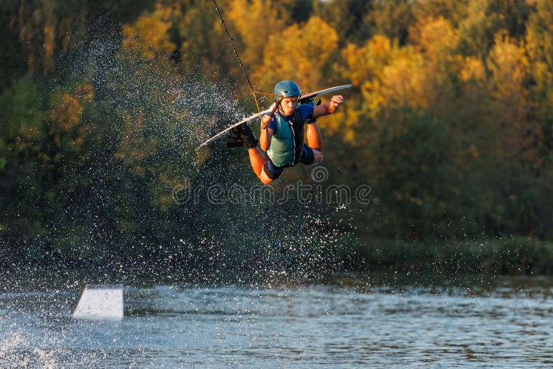 An Athlete Jumps from a Springboard. Wakeboard Park at Sunset Stock ...