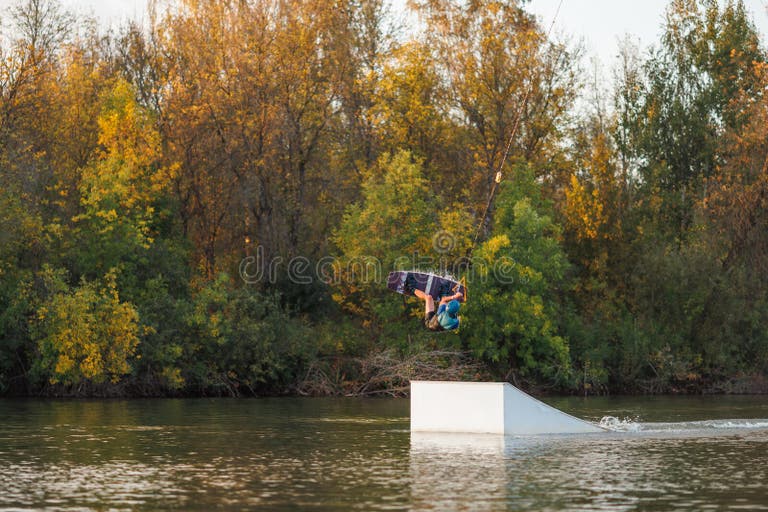 An Athlete Jumps from a Springboard. Wakeboard Park at Sunset Stock ...