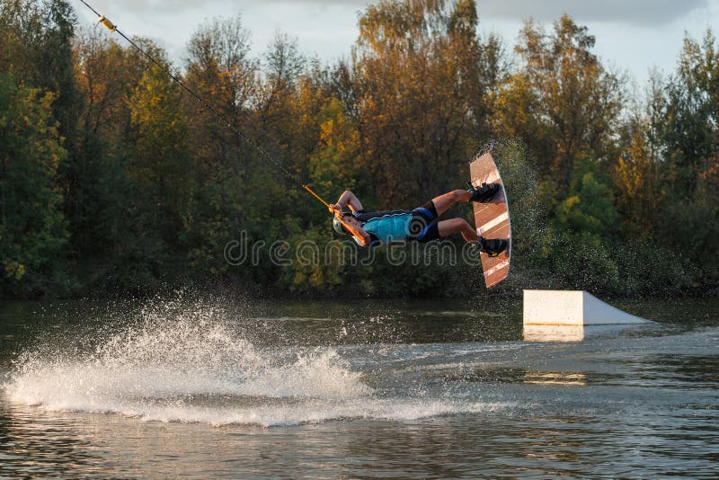 An Athlete Jumps from a Springboard. Wakeboard Park at Sunset Stock ...