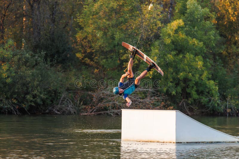 An Athlete Jumps from a Springboard. Wakeboard Park at Sunset Stock ...