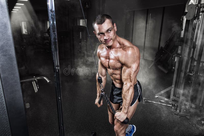 Athlete Muscular Bodybuilder Training on Simulator in the Gym Stock ...