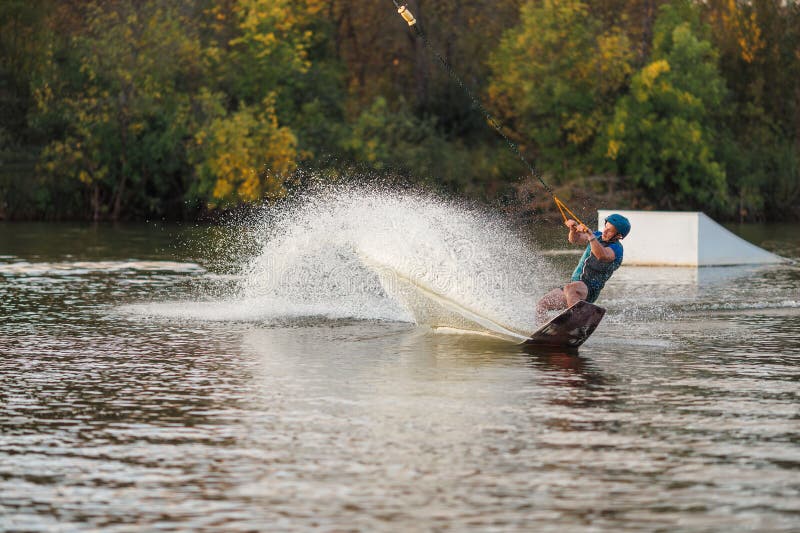 An Athlete Performs a Trick on the Water. Park at Sunset Stock Photo ...