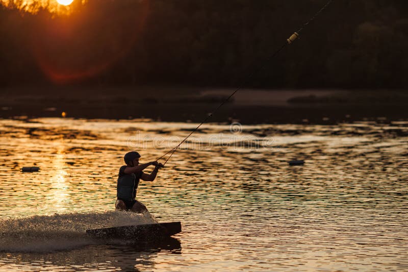 An Athlete Performs a Trick on the Water. Park at Sunset Stock Image ...