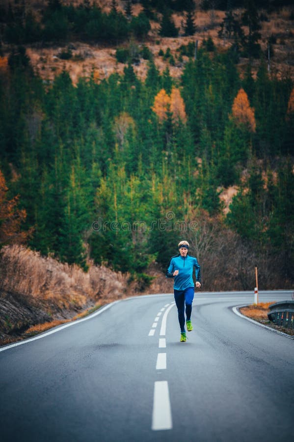 Athlete Run on the Road in Mountains. Beautiful Autumn Scenery Stock ...