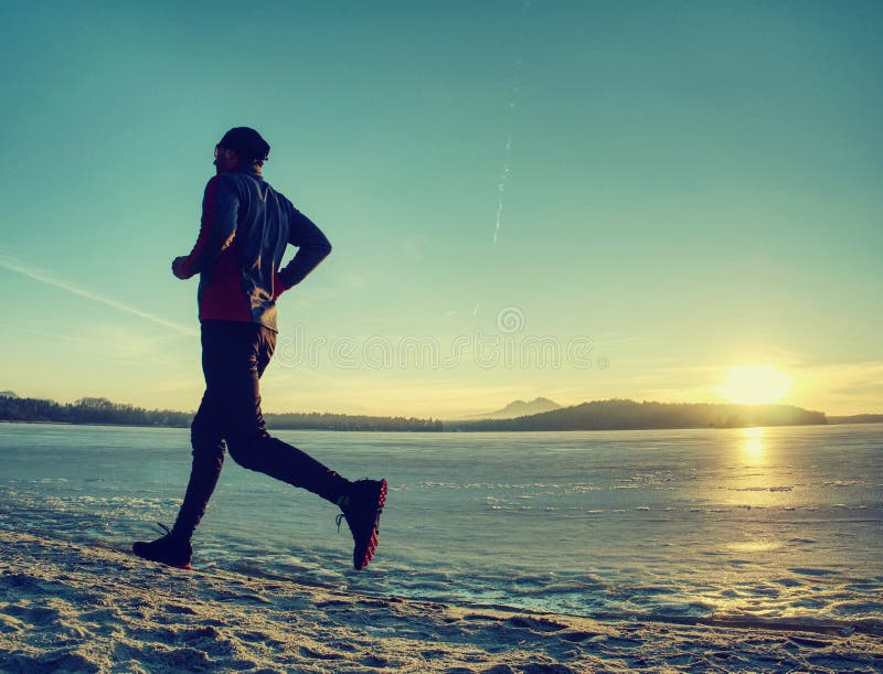 Athlete Runner Running on Beach at Frozen Lake within Sunset Stock ...