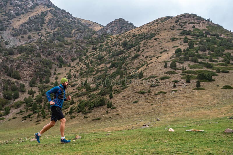 Athlete Runs High in the Mountains among the Rocks Stock Photo - Image ...