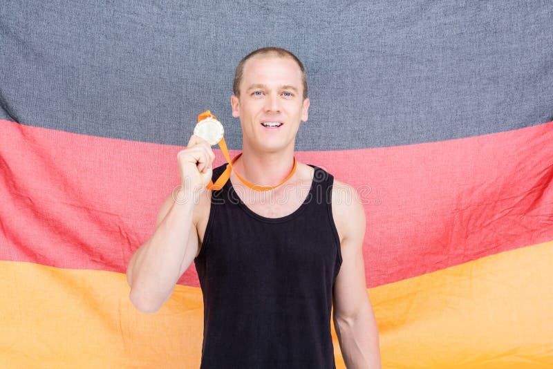 Athlete Showing His Gold Medal in Front of German Flag Stock Image ...