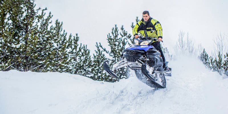 Athlete on a Snowmobile Moving in the Winter Forest in the Mountains ...