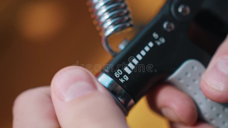 Athlete Uses an Hand Expander. Guy Trains Sitting at Stadium Stock ...