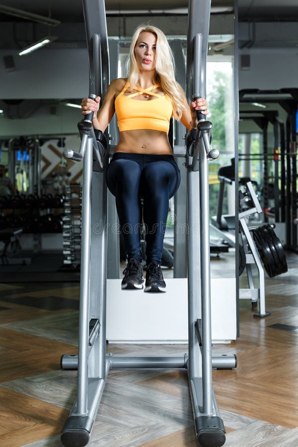 Athletic Blonde Woman Using Press Machine in Gym Stock Photo - Image of ...
