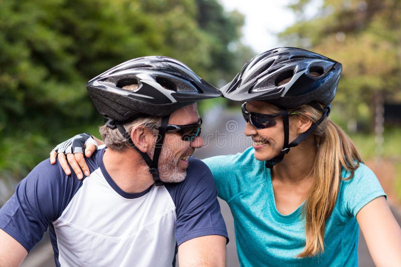 Athletic Couple Looking Face To Face while Riding Bicycle Stock Photo ...