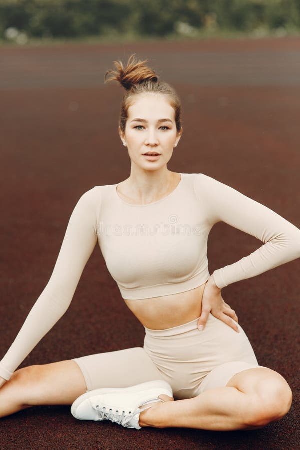 Athletic Girl On The Mat Is Warming Up Training At The Stadium With