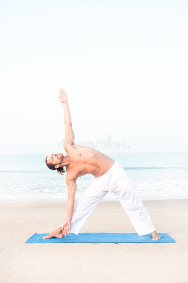 Athletic Man Doing Yoga On A Mat At The Beach Stock Photo - Image of ...
