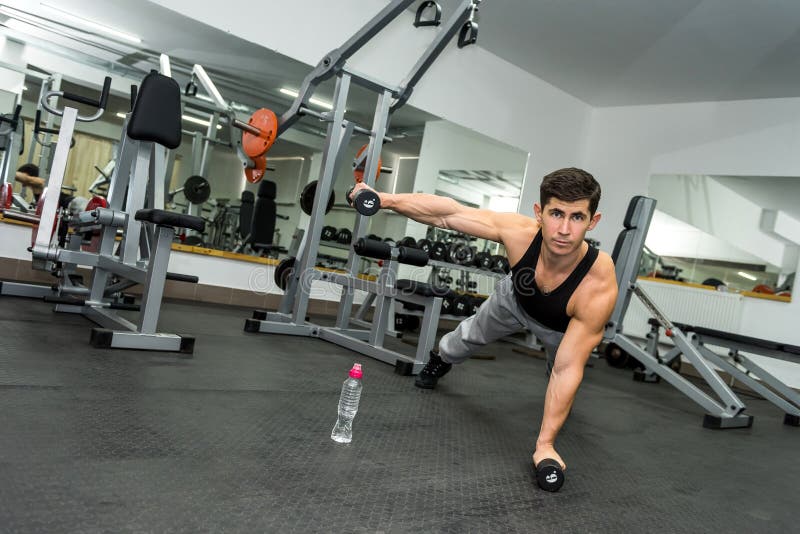 Athletic Man in Gym Working with Dumbbells Stock Photo - Image of ...