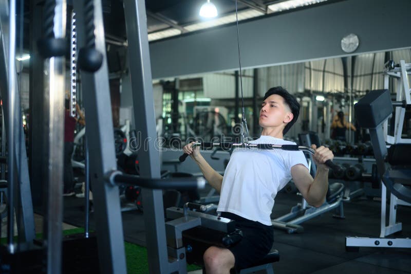 Athletic Man Working Out on a Lat Pulldown Machine in Modern Gym Stock ...