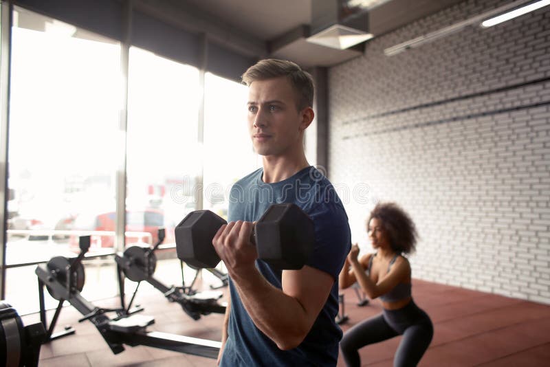 Athletic Man Doing Exercise with Dumbbell in Modern Gym Stock Photo ...