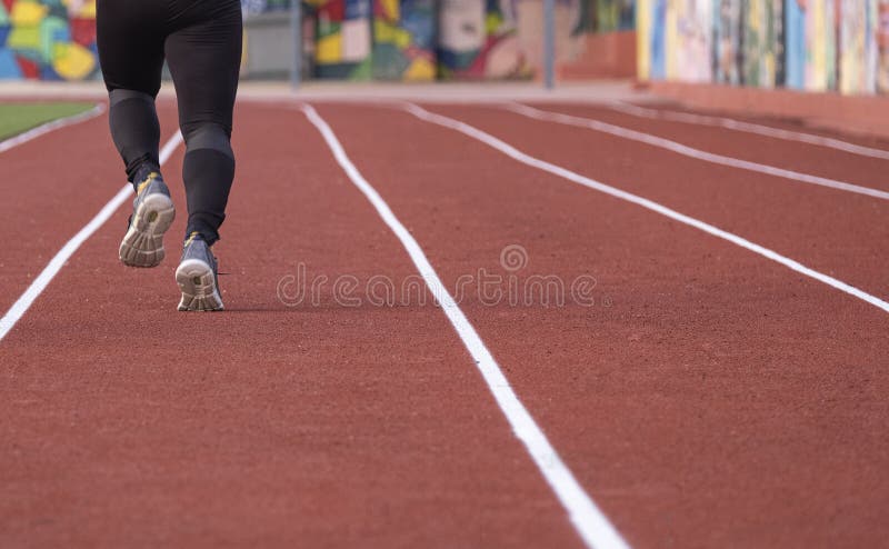 An Athletic Pair of Legs Going for a Run on a Running Track Stock Image ...
