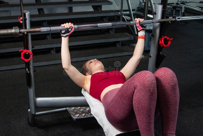Athletic Woman Doing Barbell Bench Press on a Bench in the Gym Stock ...