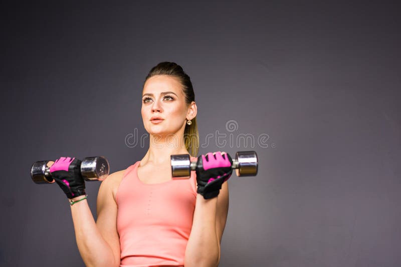 Athletic Woman Doing Exercises with Dumbbells in the Gym. Stock Image ...