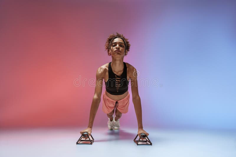 Athletic Woman is Doing Push Ups while Using Special Handles on Studio ...