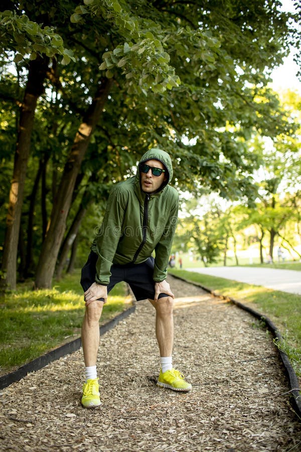 Athletic Young Man Having a Break while Doing Workout in Sunny Green ...