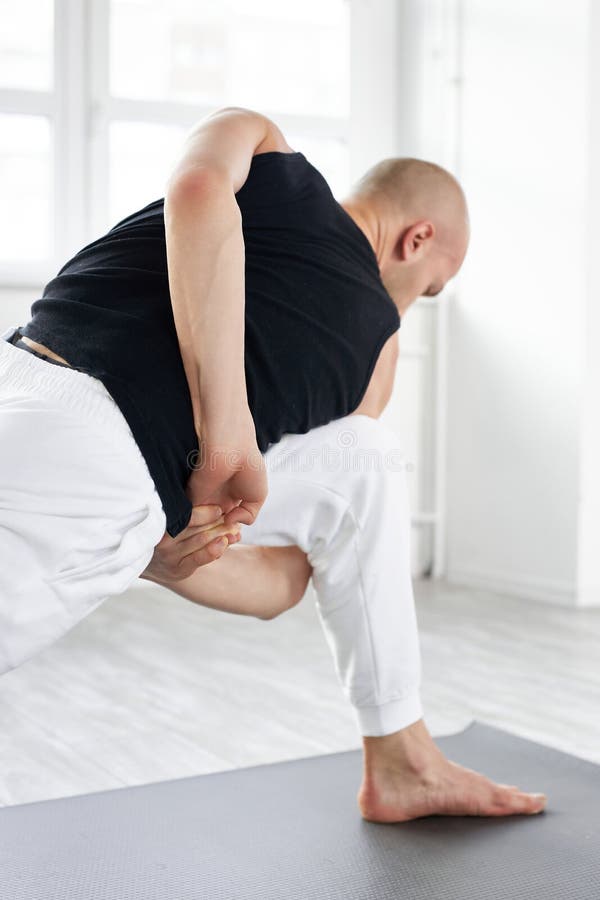 Athletic Young Man Performing Complex Exercises and Keeps Balance Stock ...