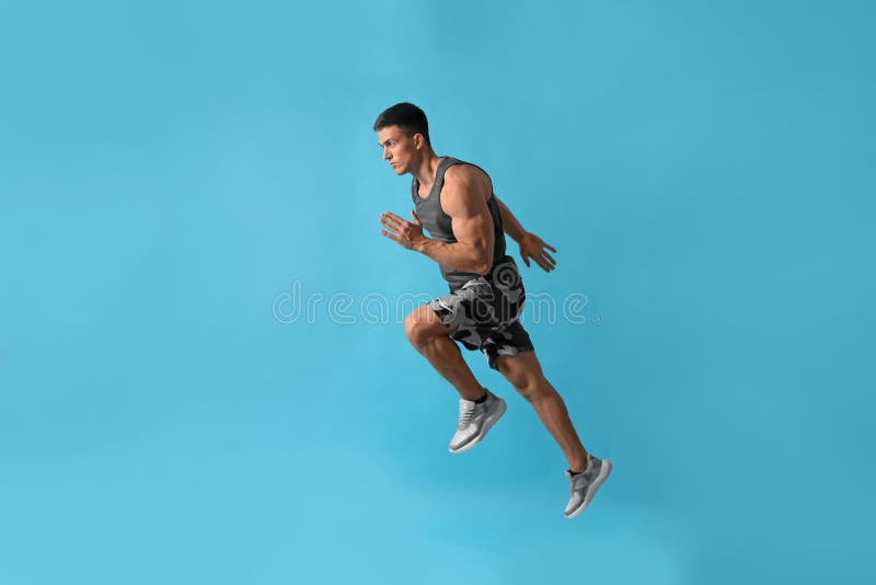 Athletic Young Man Running on Blue Background, Side View Stock Image ...