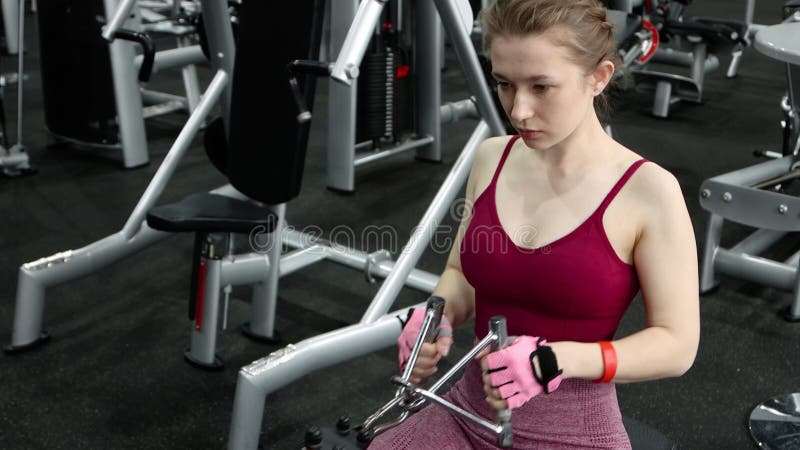 An Athletic Young Woman Trains on an Exercise Bike in the Gym, Camera ...