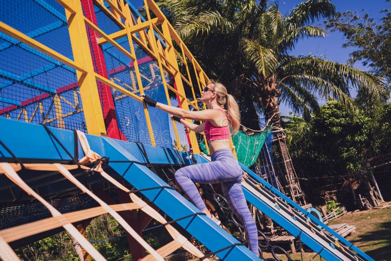 Athletic Young Woman Working Out and Climbing a Ropes at the Rope ...