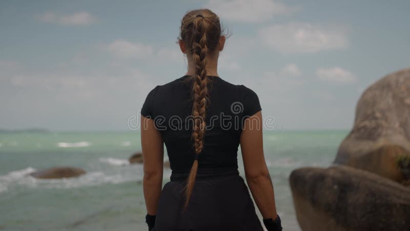 Athletically Built Female Standing on the Big Stone by the Ocean and ...