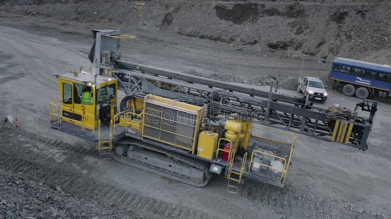 An Atlas Copco DML HP Drill Rides through an Open Pit in the Evening ...
