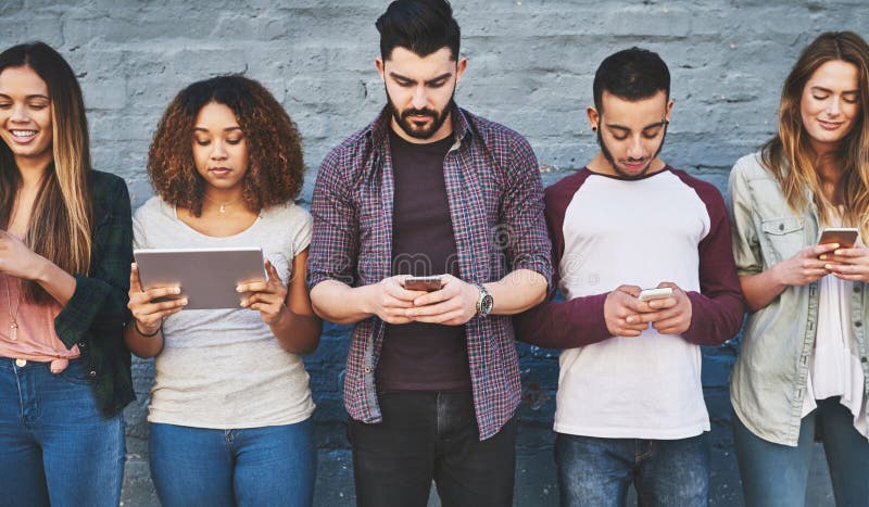 Attached To Technology. a Group of Young Friends Using Their Wireless ...