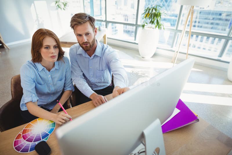 Attentive Executives Working Over Personal Computer at Desk Stock Photo ...