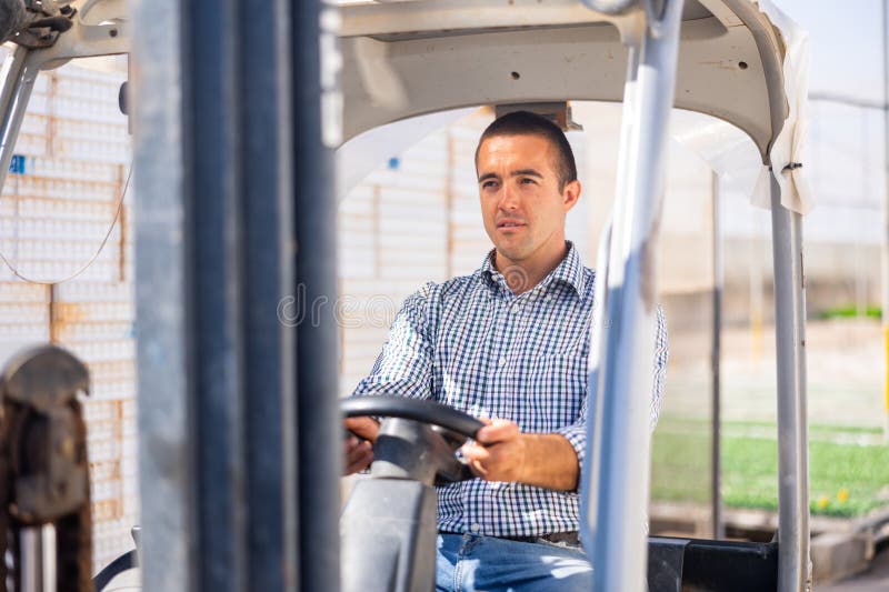Attentive Farmer Man Working on Forklift Loader at Farm Greenhouse ...