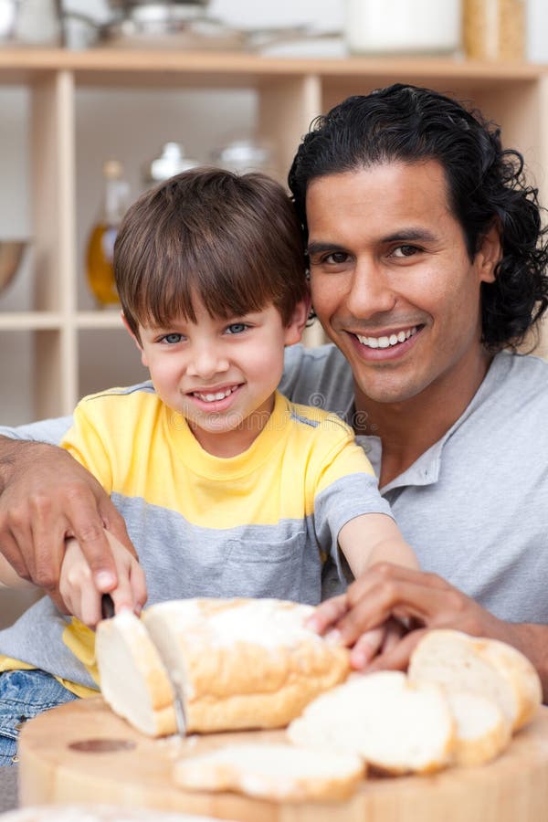 Attentive Father Helping His Son Cut Some Bread in Stock Photo - Image ...