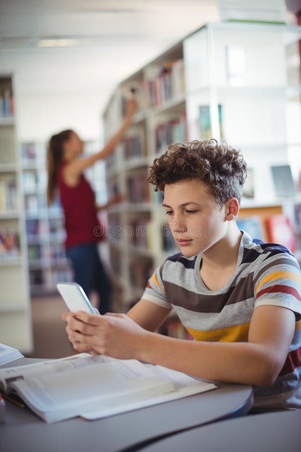 Attentive Schoolboy Using Mobile Phone while Studying in Library Stock ...