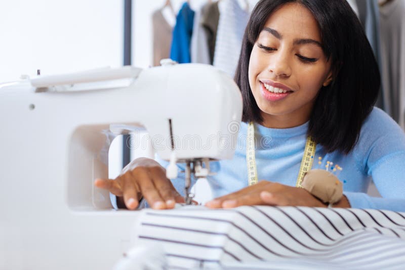 Attentive Tailor Smiling while Using a Modern Convenient Sewing Machine ...