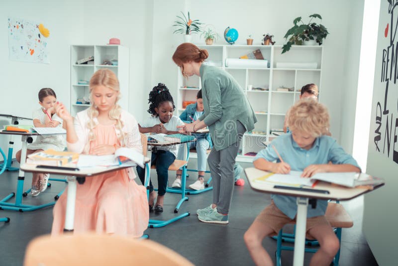 Attentive Teacher Helping Her Pupils One after Another. Stock Image ...