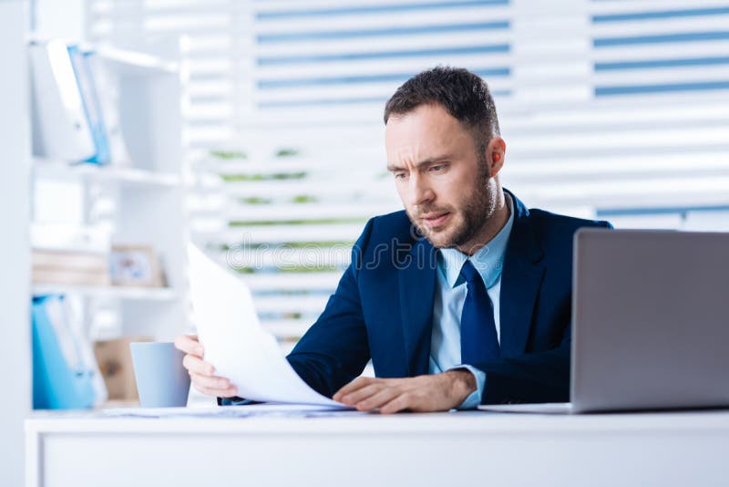 Attentive Young Manager Reading the Documents while Being at Work Stock ...