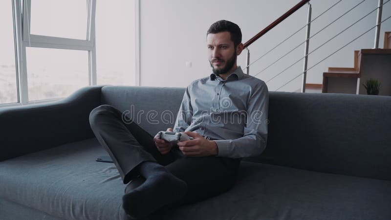 Attractive Beard Man is Sitting on Coach and Playing at Video Game ...