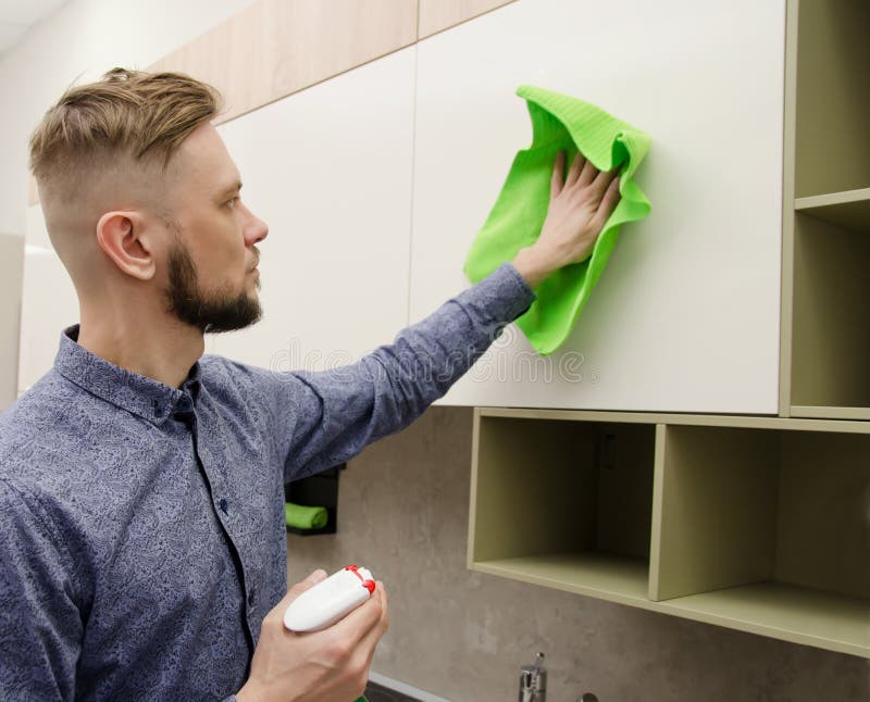 Attractive Bearded Man Cleaning the Handleless Cabinet Doors with a ...